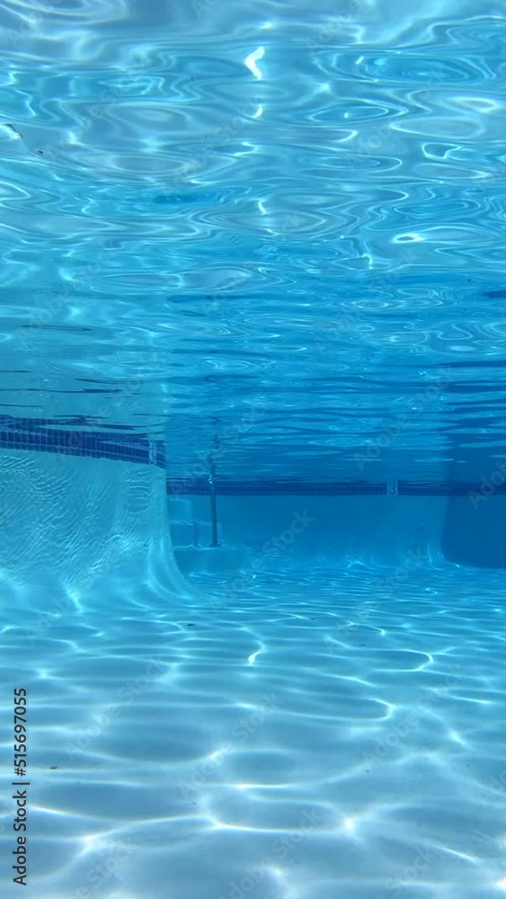 Vertical video of empty suburban swimming pool with underwater sunlight ...