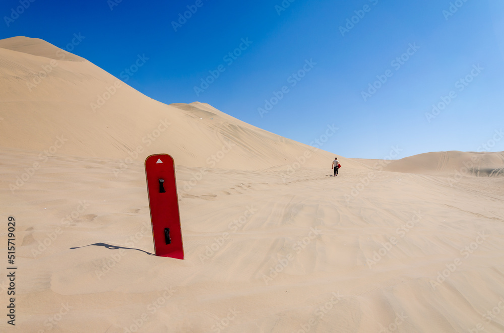 Sandboard, Sandboarding in the desert of Ica with person walking in the ...