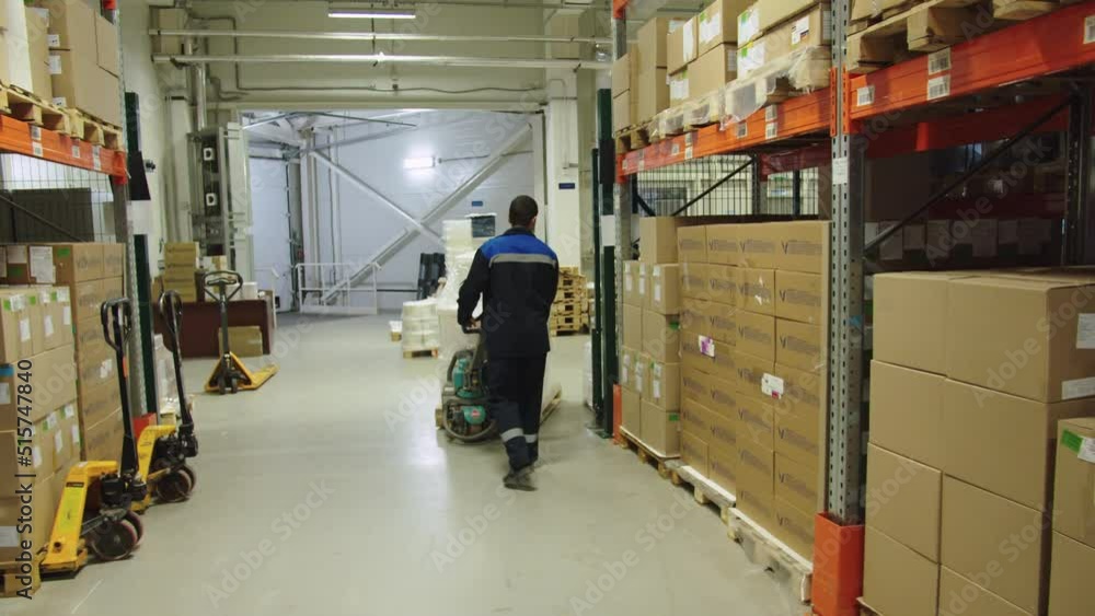 Forklift operator in special uniform is pulling the batch of packaged ...