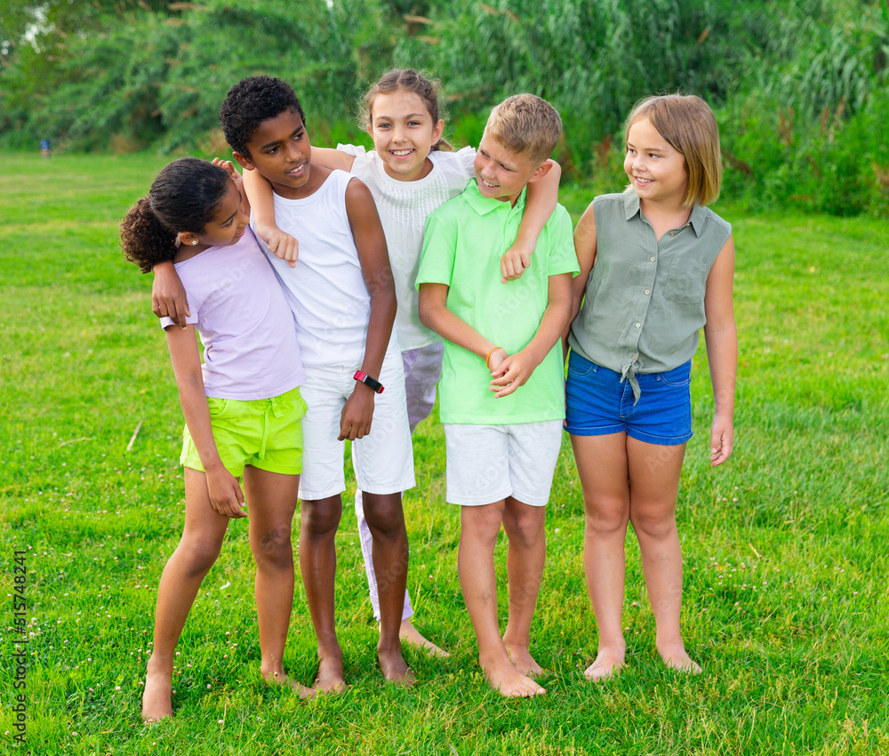 Group of five happy children who are resting together in a park on a ...