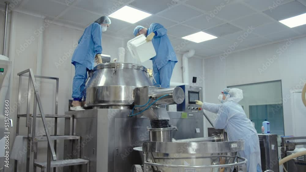 Man pours the liquid substance to automated machine for mixing and ...