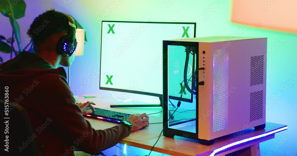 Green screen computer gamer wearing headphones and playing pc games in ...
