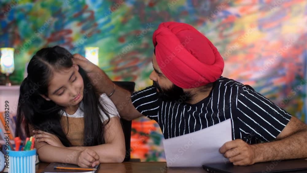 A Sikh Indian father scolding his daughter looking at her exam papers ...