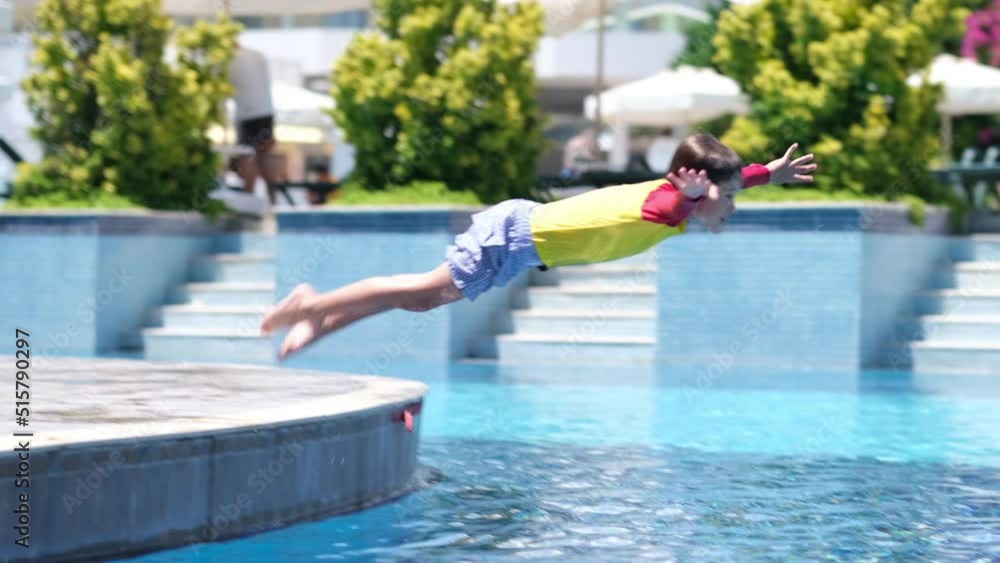Child falling into a summer outdoor pool. kid relaxing during summer ...