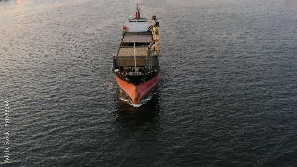 Cargo rusty ship sails on the sea at sunset. A bulk carrier is a ...