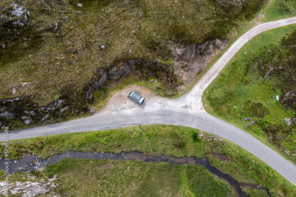 top down view of a gray campervan parked next to a small road in the ...
