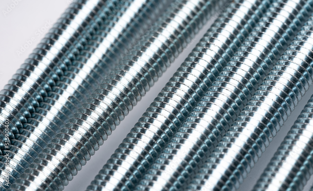 The threaded bolts are stacked side by side to create an abstract ...