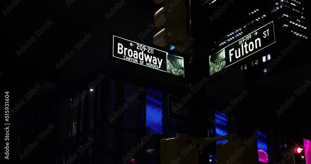 Broadway and Fulton Street signs in NYC illuminated at night. Dark ...