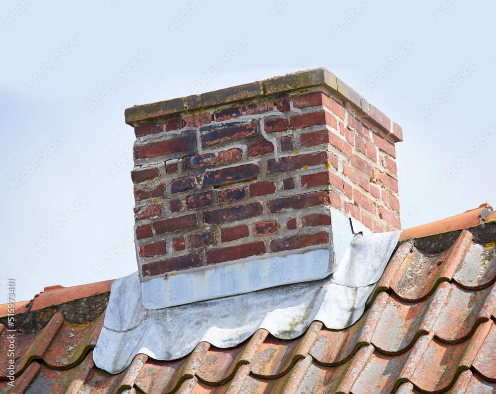 Red brick chimney designed on roof of house or building outside against ...