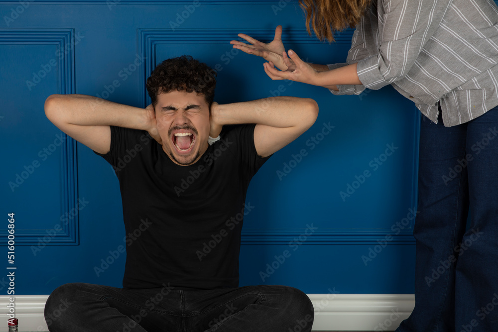 Girl bullying young man and Man sitting down and put her hands to her ...