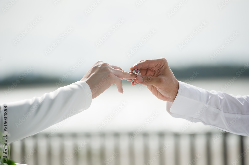 muslim groom in white suite wearing wedding rings to left ring finger ...