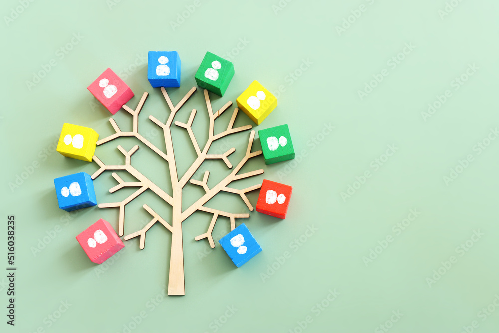 Business image of wooden tree with people icons over green background ...