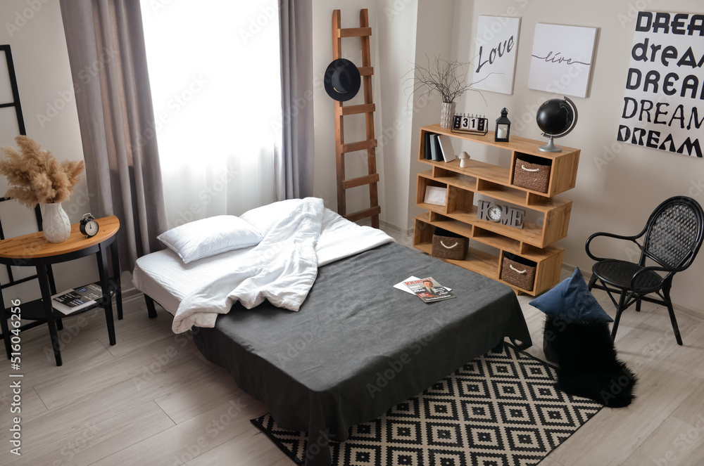 Interior of stylish bedroom with ladder and shelving unit Stock Photo ...