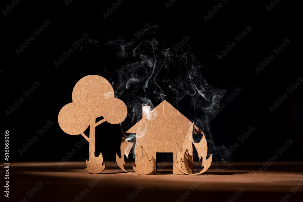 Cardboard cutout house and tree surrounded by fire flames and smoke on ...