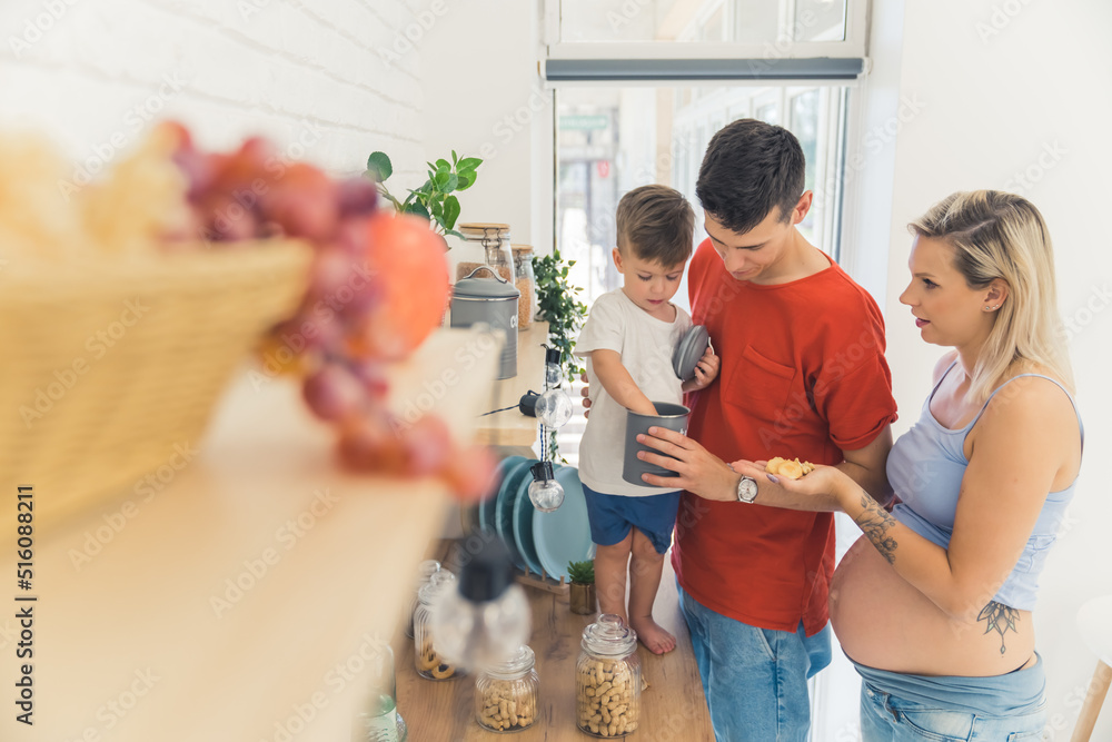 little boy checking things in the kitchen with his parents, family ...