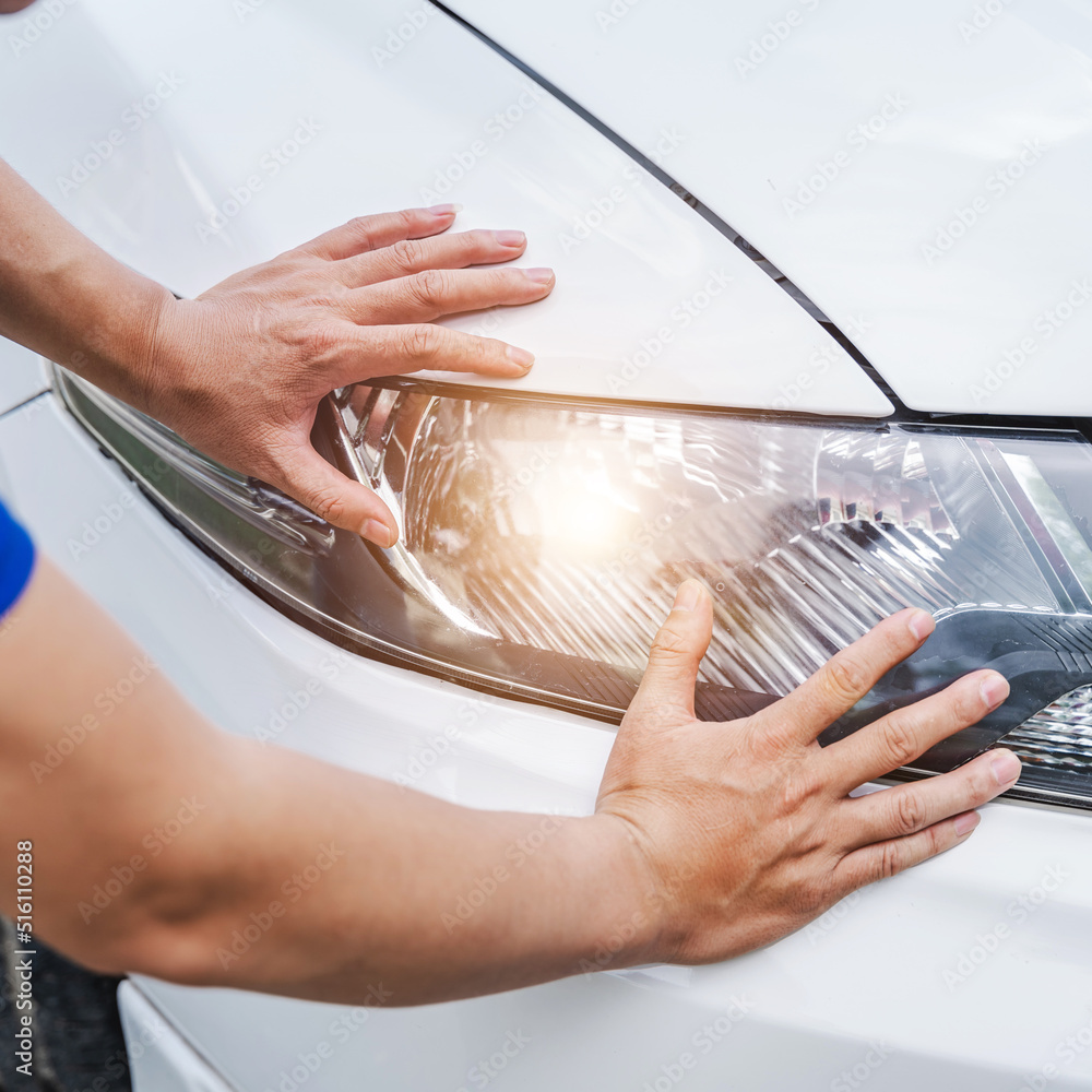 Asian auto mechanic checking headlight in auto service garage ...