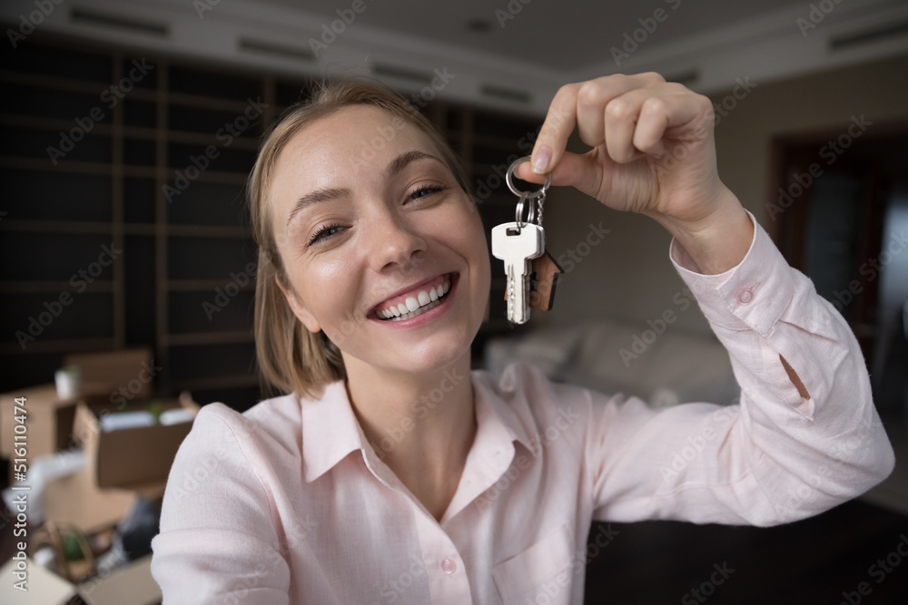 Happy cheerful new homeowner girl holding, showing keys, looking at ...