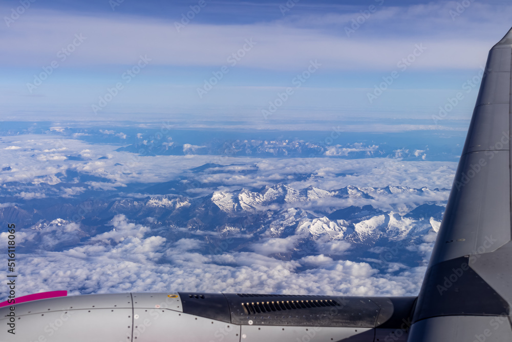 Window view from an airplane on snow capped mountain ranges of the ...