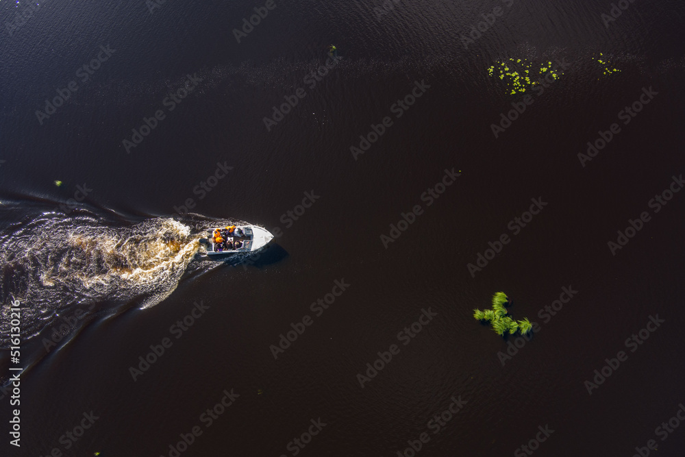 drone over the river with a speedboat at sunset. A bird's-eye view of a ...