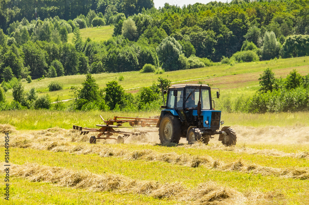 tractor with mower to mow grass in meadows . Tractor cut hay from alfalfa. Preparation of animal ...