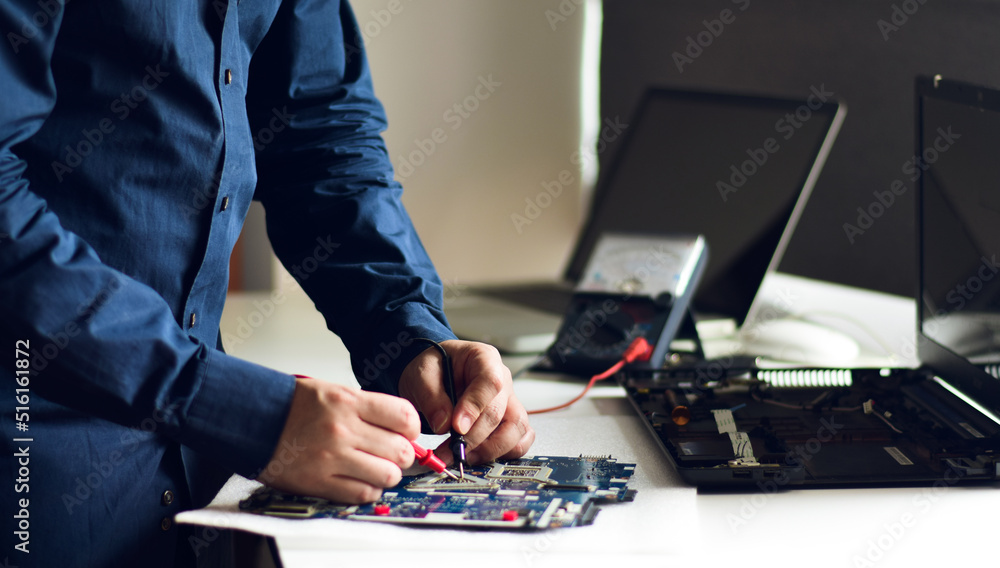 young man who is a computer technician A laptop motherboard repairman ...