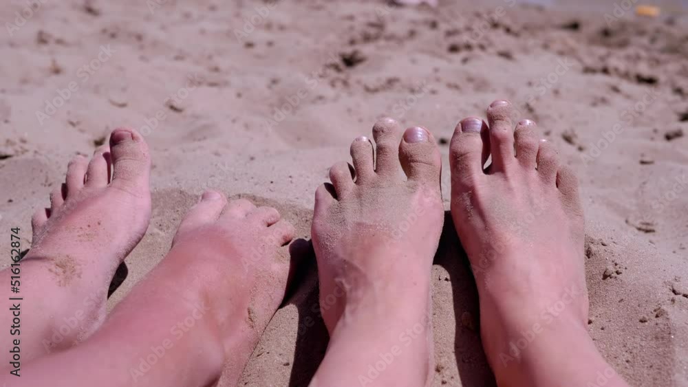 Vídeo do Stock: Tanned Red Bare Feet of Mother and Child in Sand Lies ...