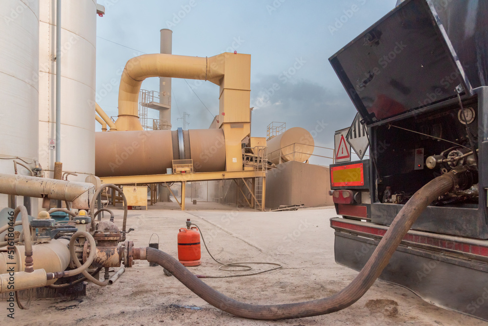 Dangerous goods tanker unloading with a motorized pump at an asphalt ...
