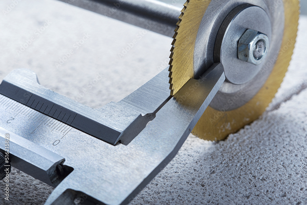 Vernier calipers measure the thickness of a circular saw blade Stock ...
