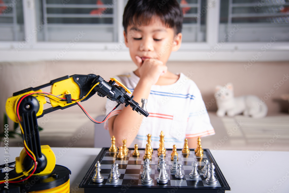 Asian little boy thinking and wait robot arm playing chess, STEM ...