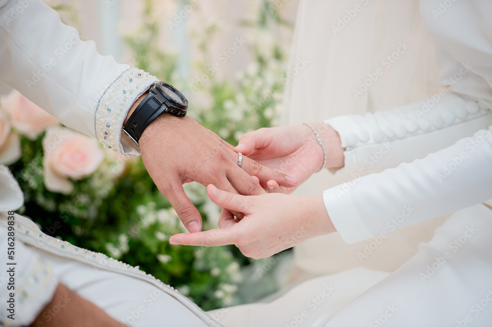 muslim bride in white dress wear wedding rings to left ring finger of ...