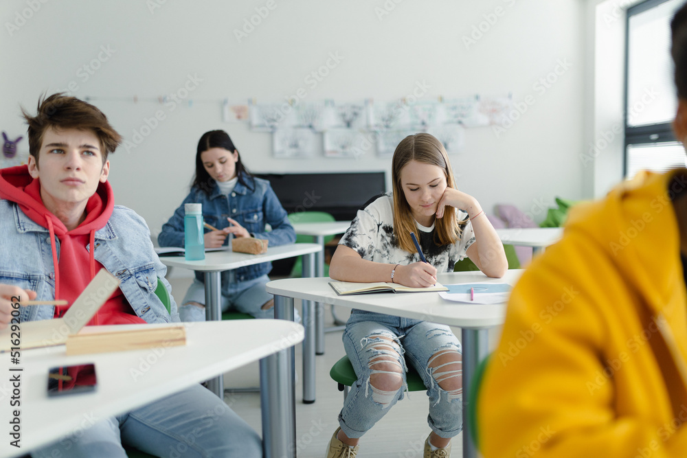 High school students paying attention in class, sitting in their desks ...