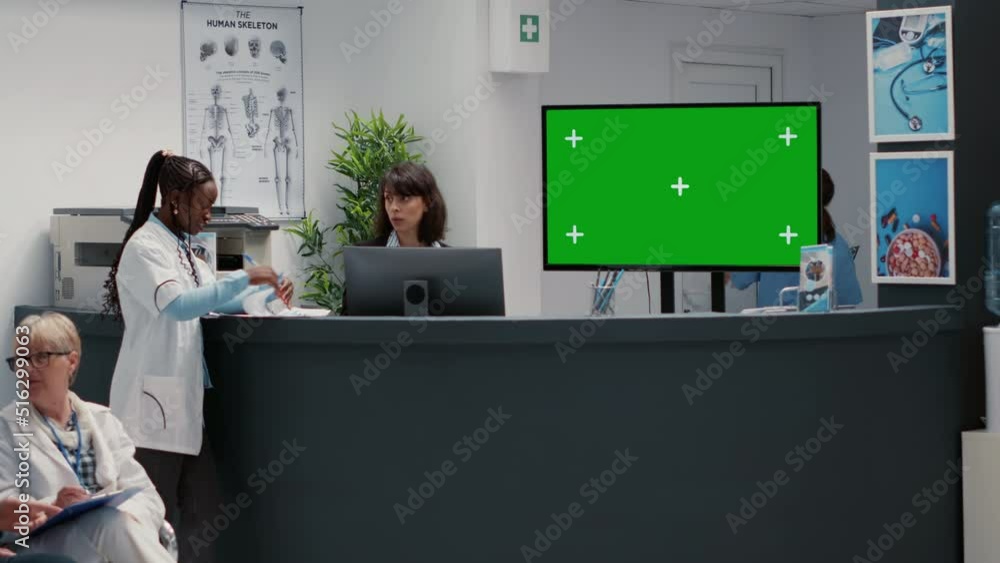 Hospital reception desk with greenscreen on tv monitor in waiting room ...
