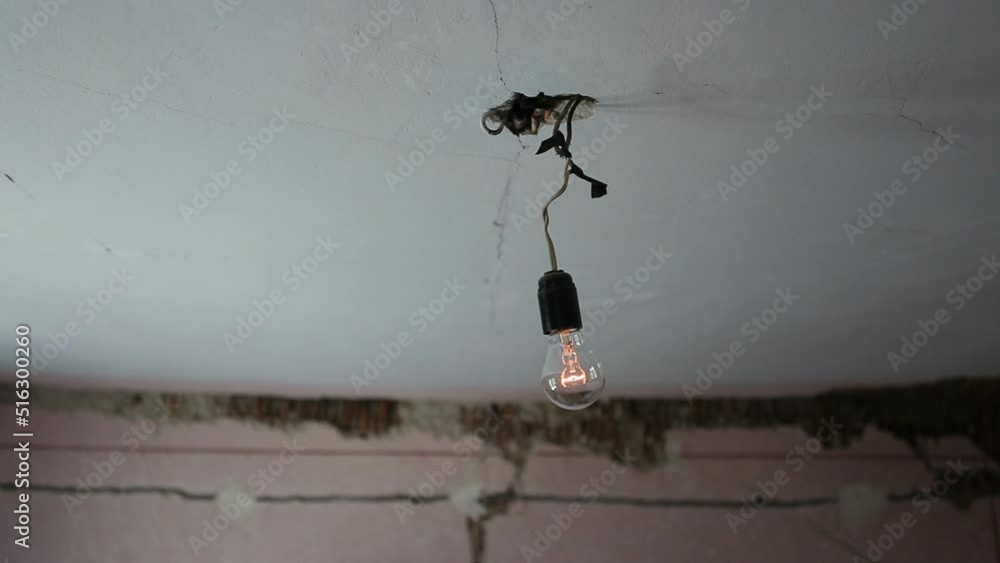 An electric light bulb with an incandescent spiral flickers and does ...