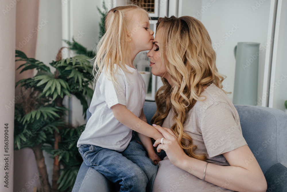 Pregnant Swedish Woman In Beige T Shirt Sitting With Her Daughter In