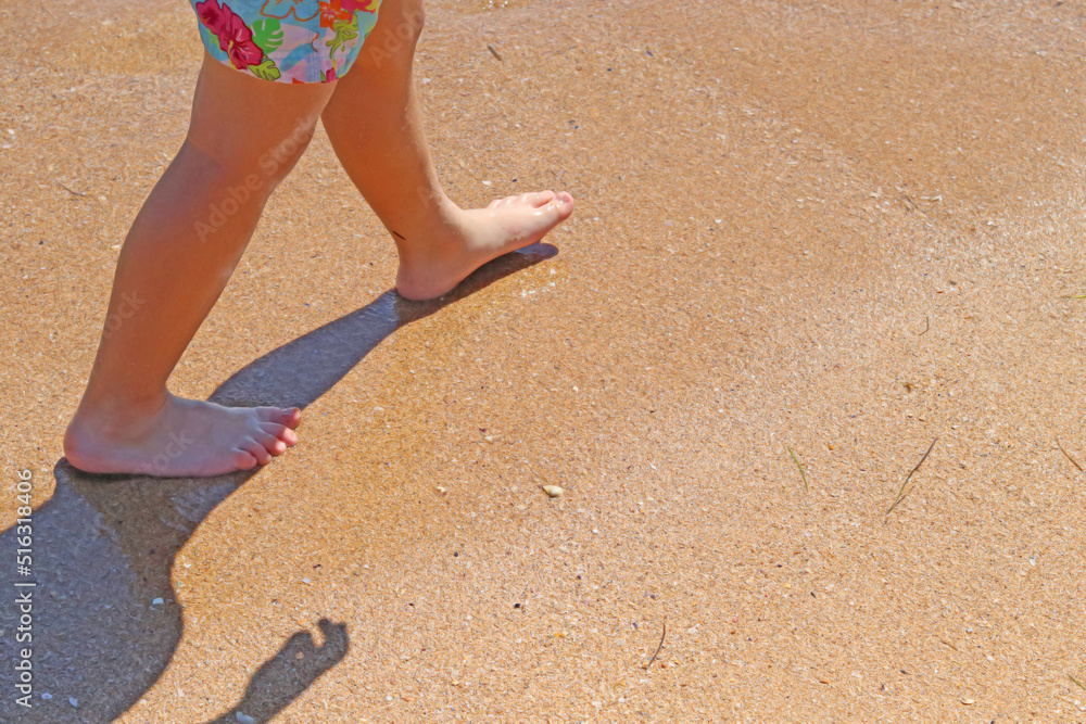 Boy walking barefoot on a beach Stock Photo | Adobe Stock