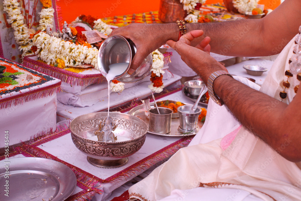 Puja in a Hindu temple : bathing of a statue of goddess Durga with milk ...