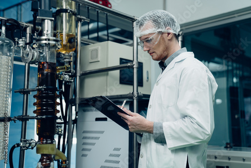 Scientist holding paper board and checking rotational vaporizer during ...