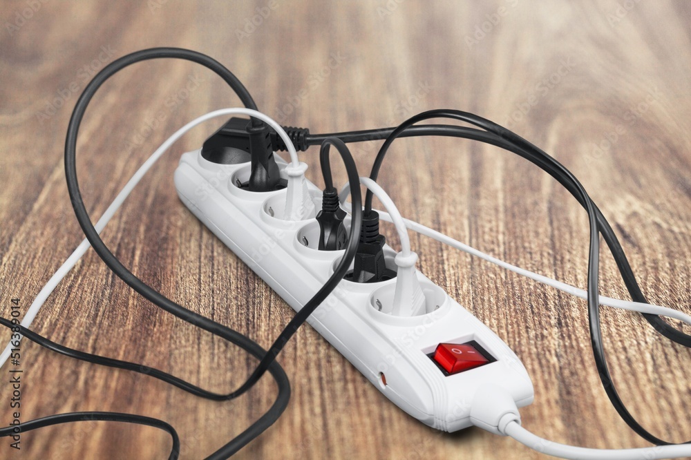 Unplugged electric appliance plug over switched off white power strip ...