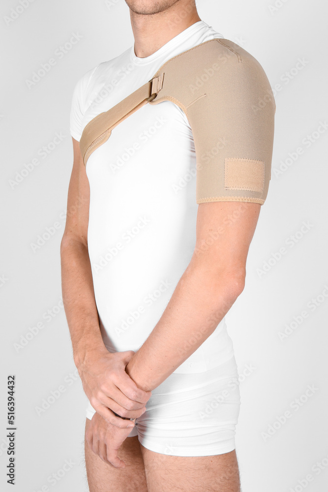 Shoulder joint orthosis or brace isolated on white background. A man in ...