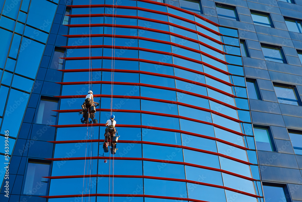 Two workers cleaning window in business center, Industrial alpinists ...