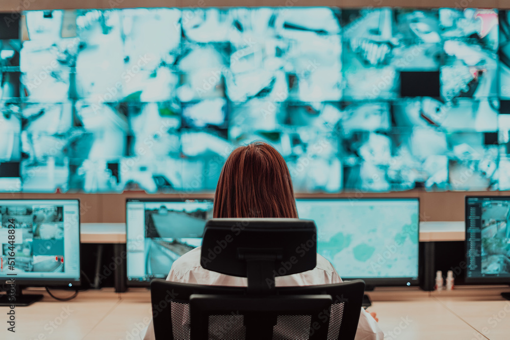 Female security operator working in a data system control room offices ...