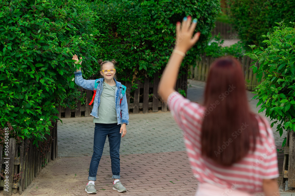 Girl with Down syndrome waving to her mother as she goes to school ...