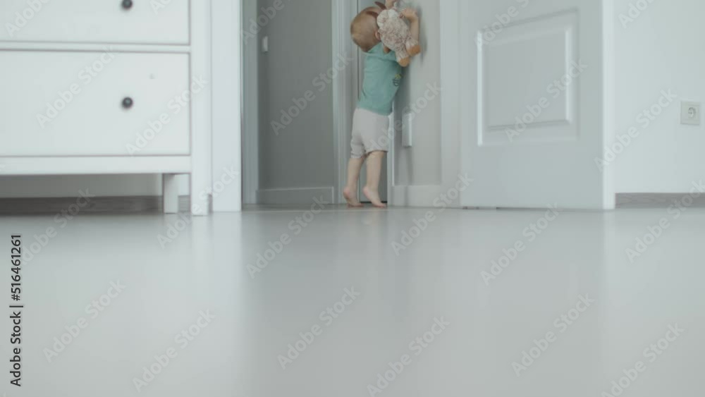 toddler baby boy standing tiptoes turning light off in room. kid ...