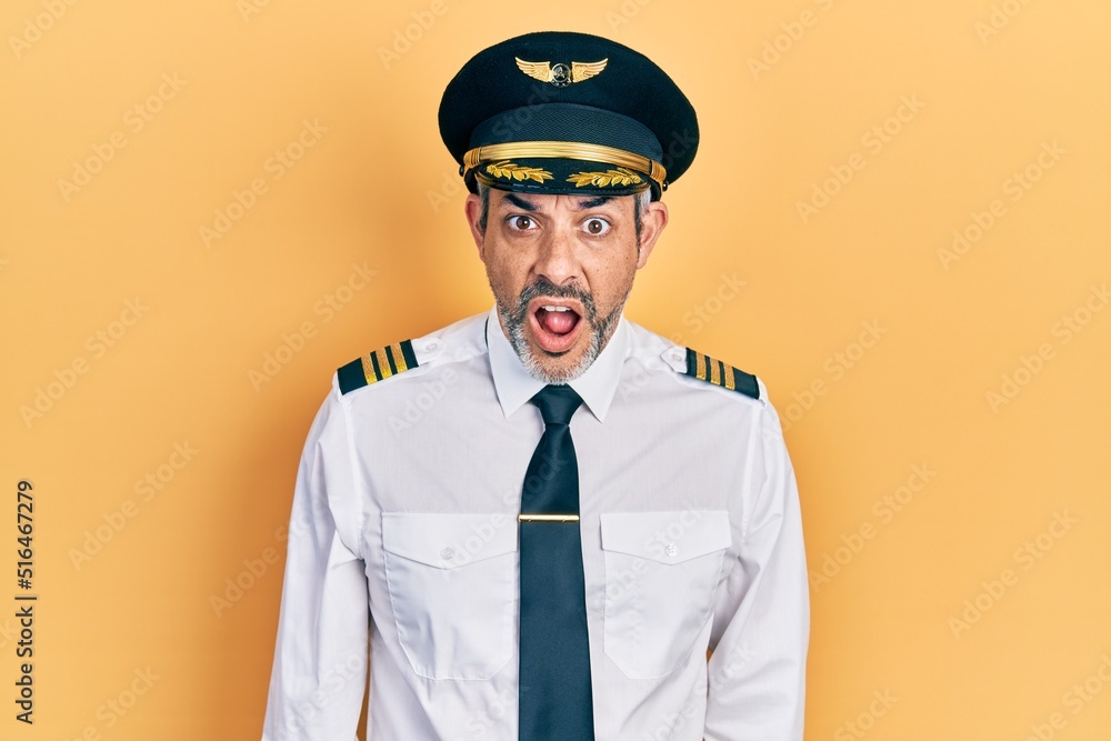 Handsome middle age man with grey hair wearing airplane pilot uniform ...