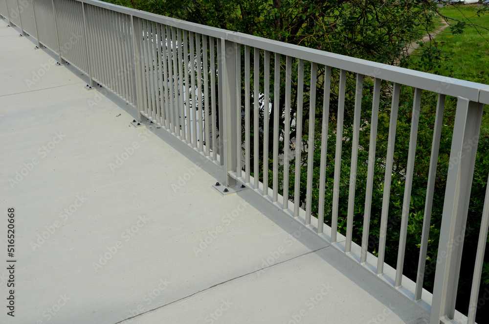 railing at the bridge with vertical fence bars anchored to the ground ...