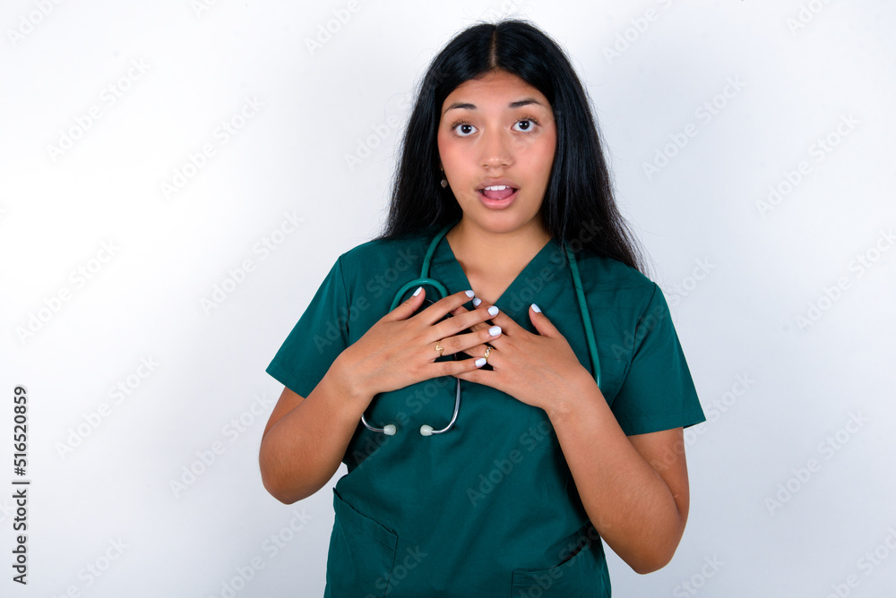 Fotka „Scared Doctor hispanic woman wearing surgeon uniform over white ...