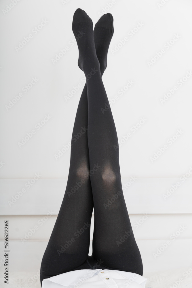 Beautiful woman putting on stocking indoors, closeup. Beautiful long ...