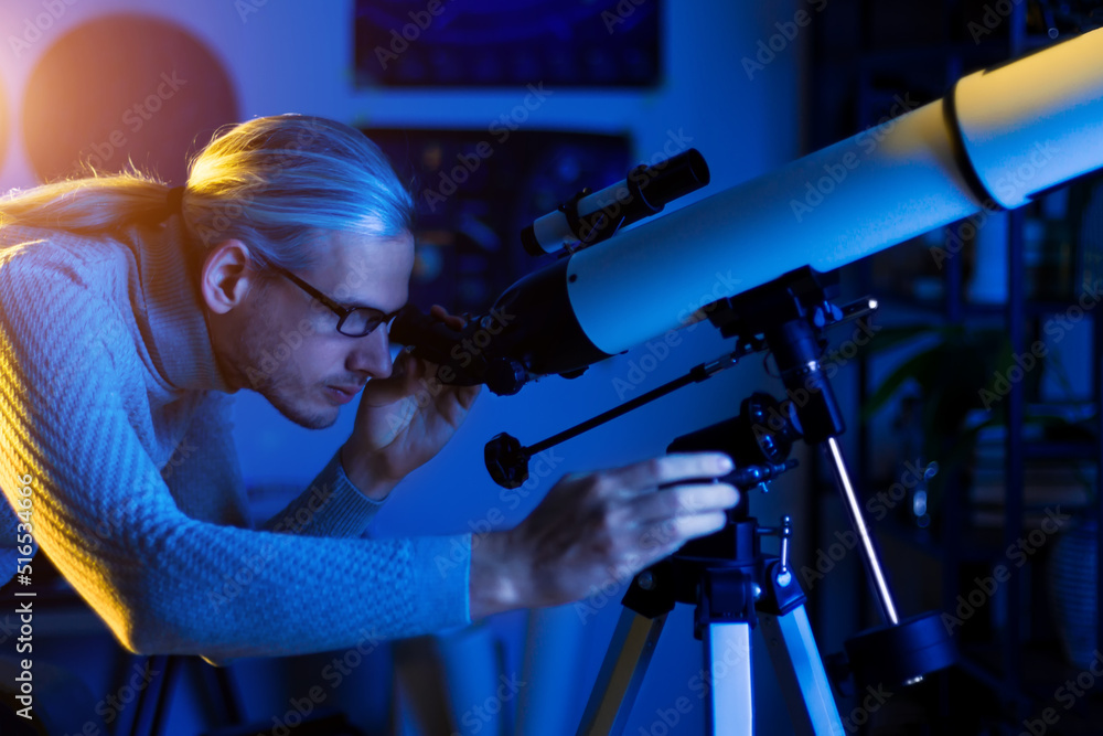 Astronomer man looks through telescope at the night sky, space, cosmos ...