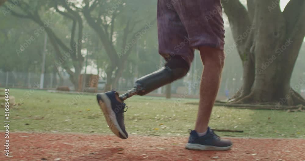 Disabled Athlete running with prosthetic leg at running track ...