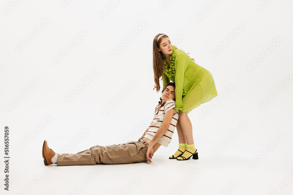 Portrait of young mysterious woman dragging unconscious man isolated ...